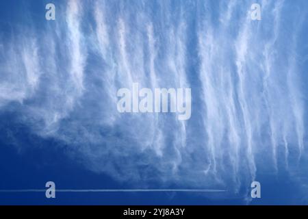 Cirrus clouds and long airplane trail row. Aero plane contrail in blue ...