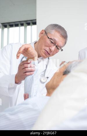 Doctor examining hospitalised senior patient in bed Stock Photo - Alamy