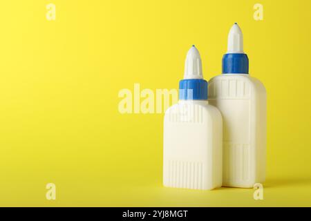 Two bottles of glue on yellow background Stock Photo - Alamy