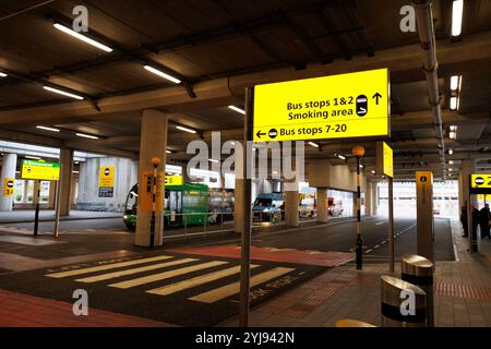 12 Nov. 2024. A bus terminal sign and smoking area at London Heathrow ...