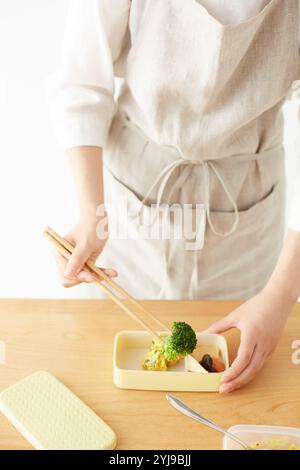 Woman packing food in Tupperware into a lunchbox Stock Photo - Alamy