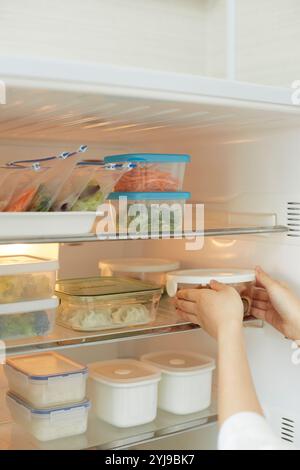 People's hands taking Tupperware out of the fridge Stock Photo - Alamy