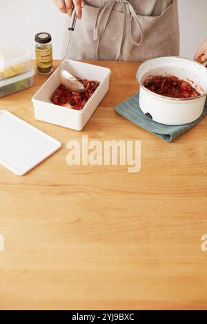 Woman transferring food to Tupperware Stock Photo - Alamy