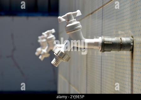 lined plastic white water faucets for ablution Stock Photo - Alamy