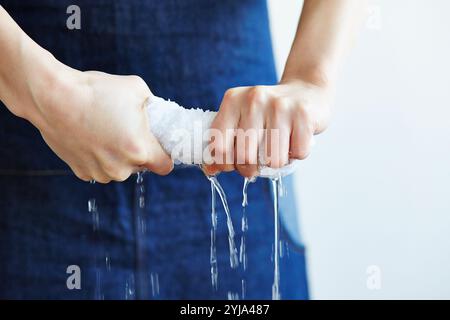 Woman's hand squeezing blue rag Stock Photo - Alamy