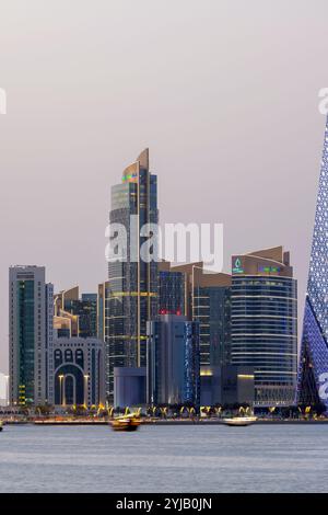Doha, Qatar skyline from the corniche promenade at night with dhows and ...