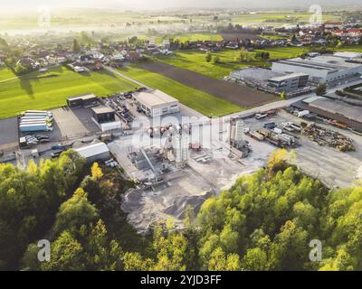 Aerial view of a factory in the suburbs with roof top covered with ...