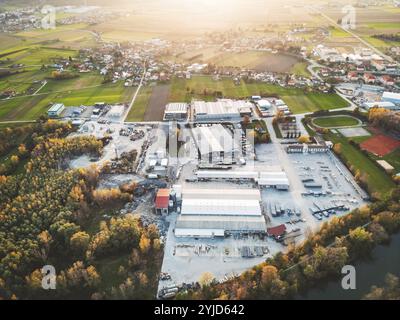 Aerial view of a factory in the suburbs with roof top covered with ...