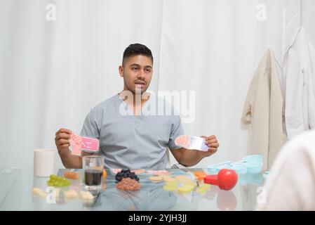 A nutritionist explains to a patient while pointing at a table with ...