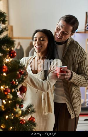 Young couple decorates Christmas tree at backyard Stock Photo - Alamy
