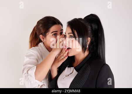 business women tell a secret: on white background Stock Photo - Alamy