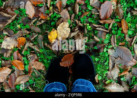 Black boots on brown leaves Stock Photo - Alamy