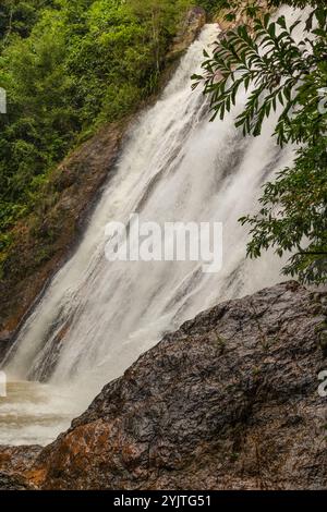 A powerful waterfall cascading down a steep, rocky cliff surrounded by ...