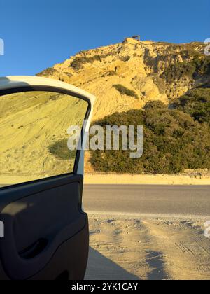 Scenic coastal road through lush tropical jungle under bright blue sky ...