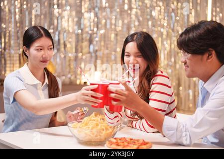 A festive gathering of friends sharing laughs, food, and drinks during ...