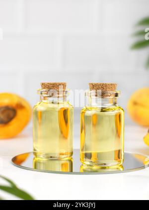 Transparent bottle with apricot essential oil and fresh apricot fruit ...