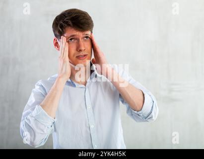 Young man experiencing acute headache in living room Stock Photo - Alamy