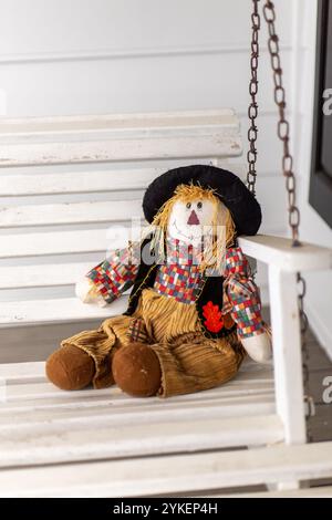 Stuffed Scarecrow on White Front Porch Swing Stock Photo - Alamy