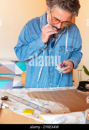 Adult man designing a piece of clothing at home for sewing Stock Photo ...