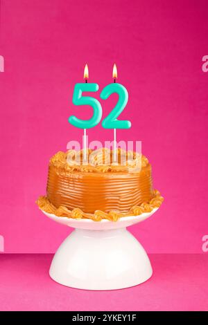 Pink number 52 birthday candle lit on white background Stock Photo - Alamy