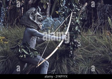 Asaro warrior, also known as Holosa, in clay mud man mask with bow and ...