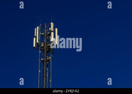 High 5g mobile antenna against blue sky background Stock Photo - Alamy