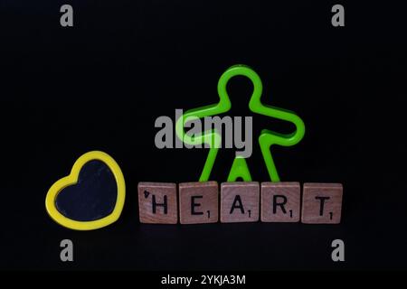 Fluorescent human shaped plastic figure and yellow heart and scrabble ...