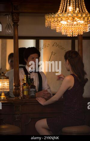 Female customer drinking cocktail with barman Stock Photo - Alamy