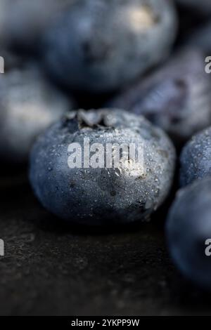 mature blueberries scattered on a black slate , a pile of blueberries ...