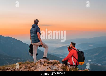 Two friends travelers enjoys a break look at the top of the mountain ...