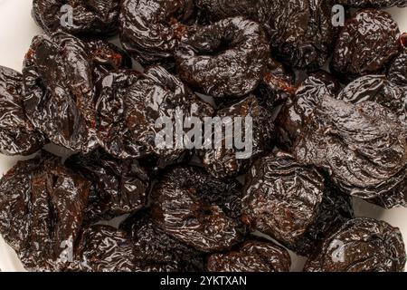 Sweet prunes in a ceramic plate on a slate stone, macro, top view Stock ...