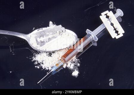 Close-up spoon with drugs powder and syringe with razor. Drug use ...