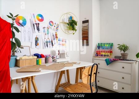 Interior of light atelier with tailor's workplace, mannequin and shelf ...