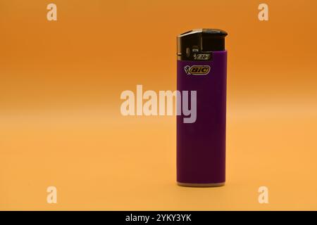 Purple lighter against an orange background Stock Photo - Alamy