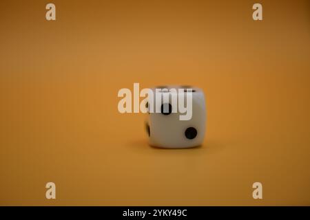 Dice against orange background. The number one Stock Photo - Alamy