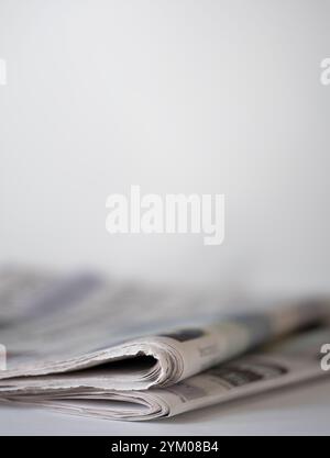 Pile of newspapers on a white table Stock Photo - Alamy