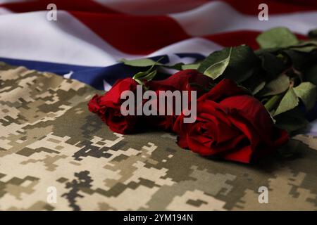 Veterans day. Rose flowers and military uniform on American flag ...