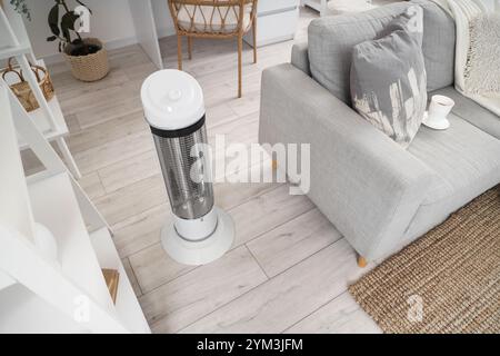 Electric heater near sofa in kitchen interior Stock Photo - Alamy