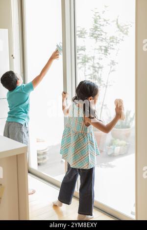 Brother and sister cleaning window Stock Photo - Alamy