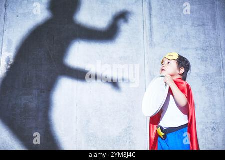 Little Superman fighting the bad guys Stock Photo - Alamy
