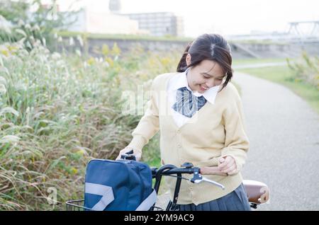 Female student pulling a bicycle Stock Photo - Alamy