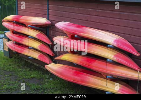 Storage of red kayaks and boats in hangar Stock Photo - Alamy