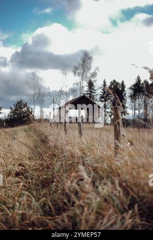 A moody landscape depicting a rural scene, featuring a collection of ...
