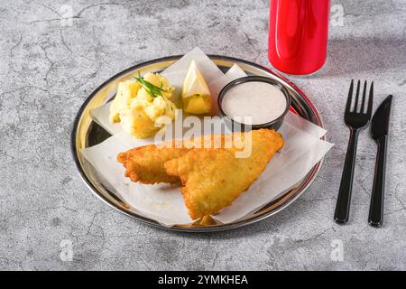 Deep fried coated fish fillet with potato salad on stone table Stock ...
