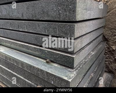 Granite slabs stand in rows. Granite slabs for tombstones. Workshop for ...