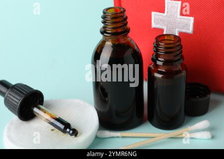 Topical iodine and other first aid kit components on light blue ...