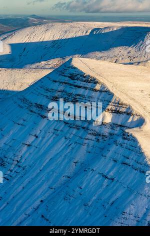 Snow covered Cribyn in the Brecon Beacons, illuminated by a break in ...