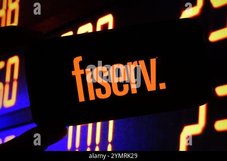 In this photo illustration, the Fiserv company logo is seen displayed ...