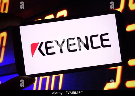 In this photo illustration, the Keyence company logo is seen displayed ...