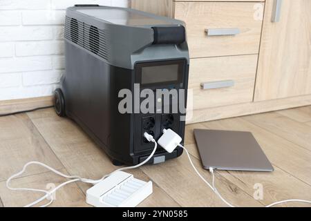 Modern portable power station, charging attached devices indoors Stock ...
